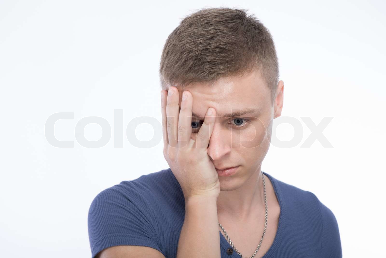 Sad young man covered his face with his hand | Stock image | Colourbox