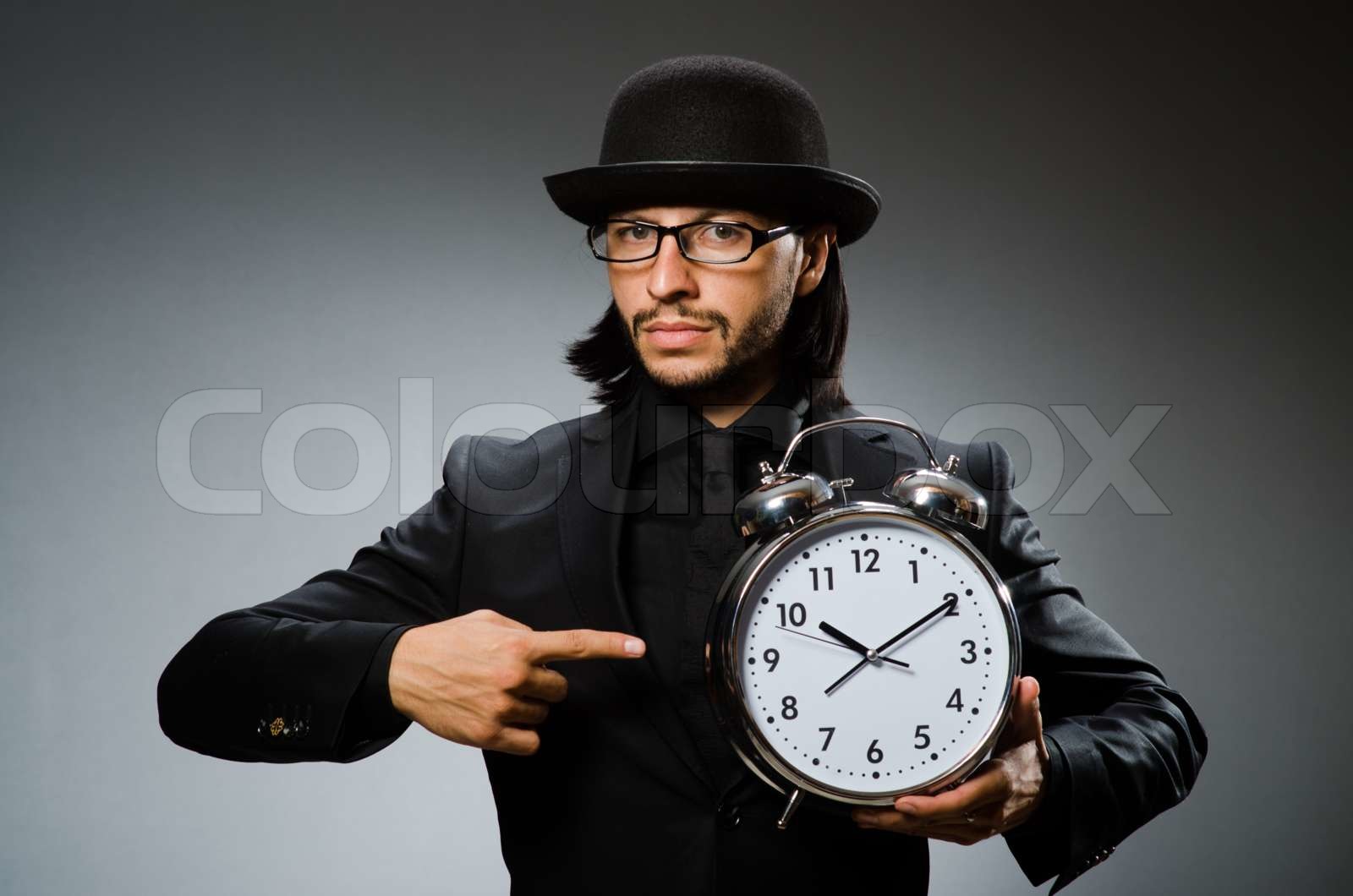 Man with clock wearing vintage hat | Stock image | Colourbox