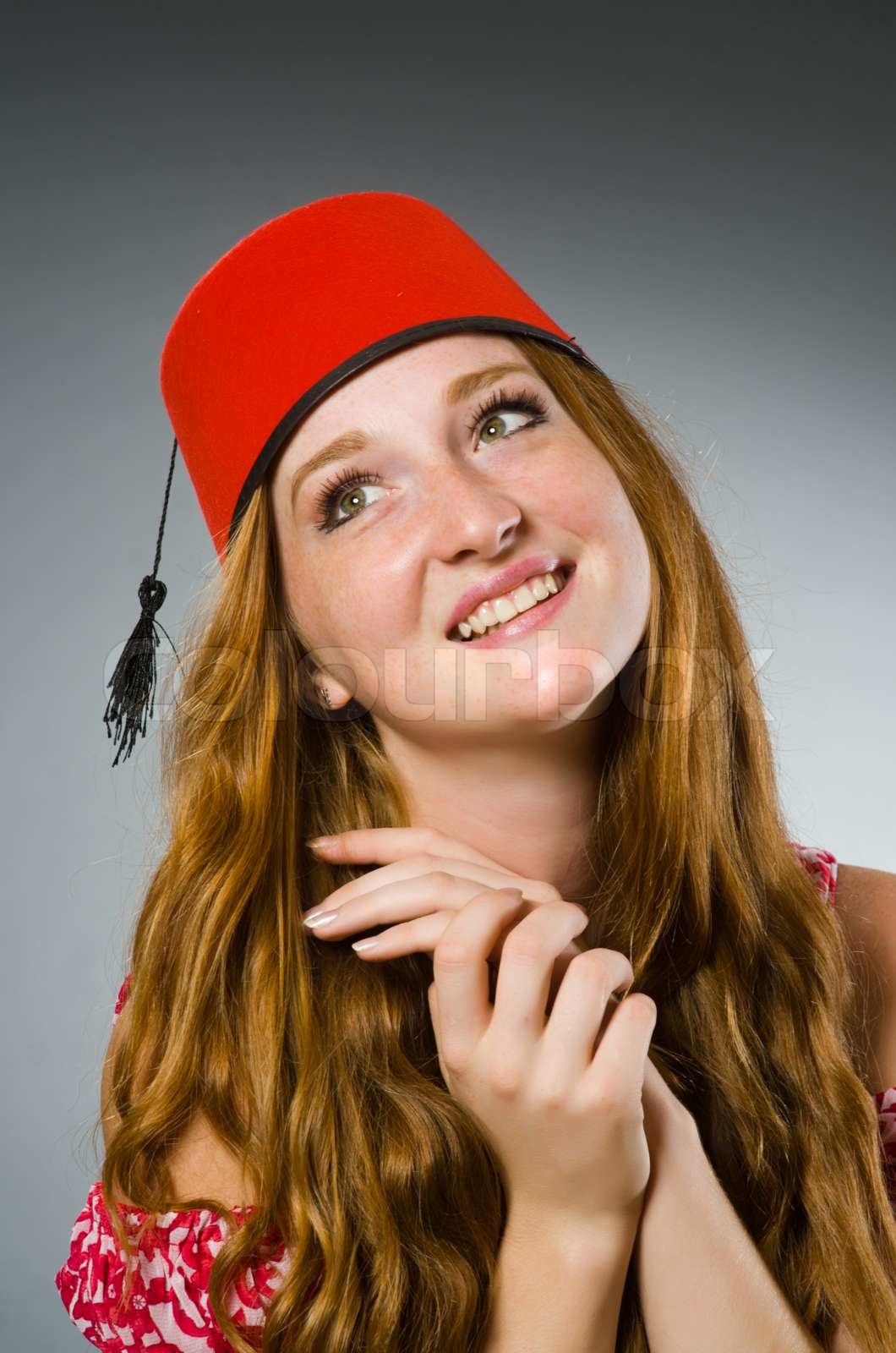 Woman wearing red fez hat | Stock image | Colourbox
