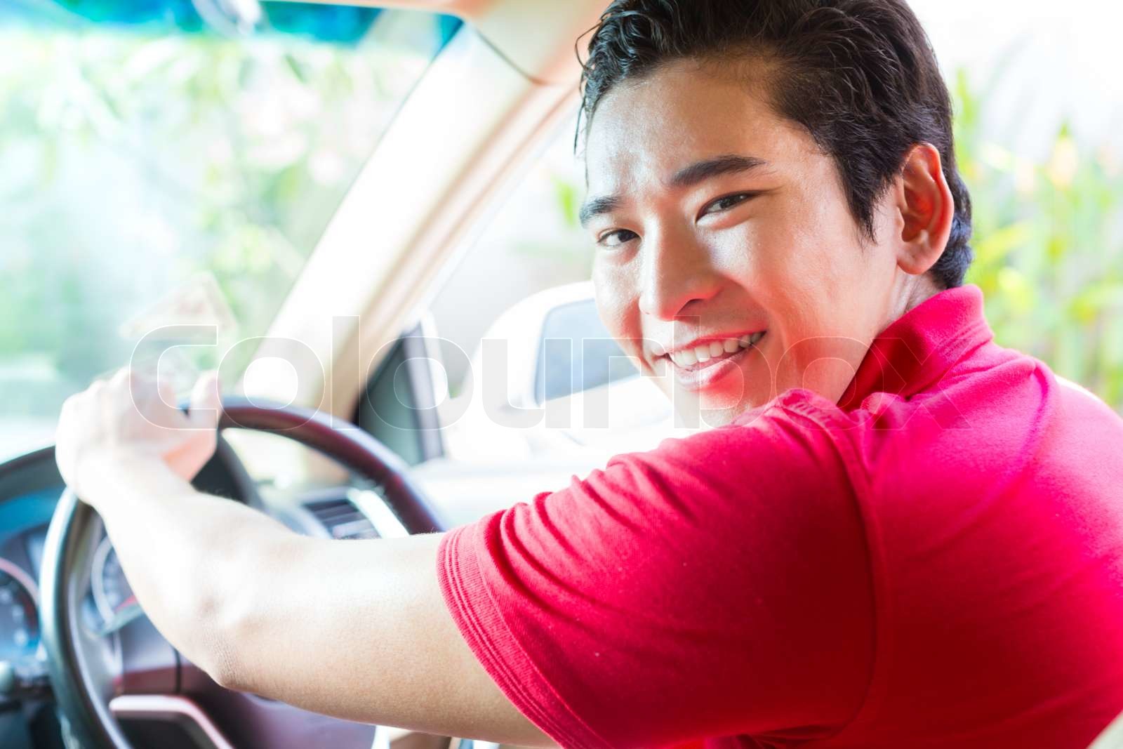Asian man driving new car | Stock image | Colourbox