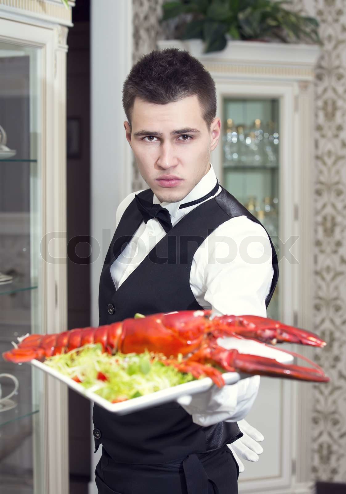 waiter with a tray of food in the restaurant hall | Stock image | Colourbox