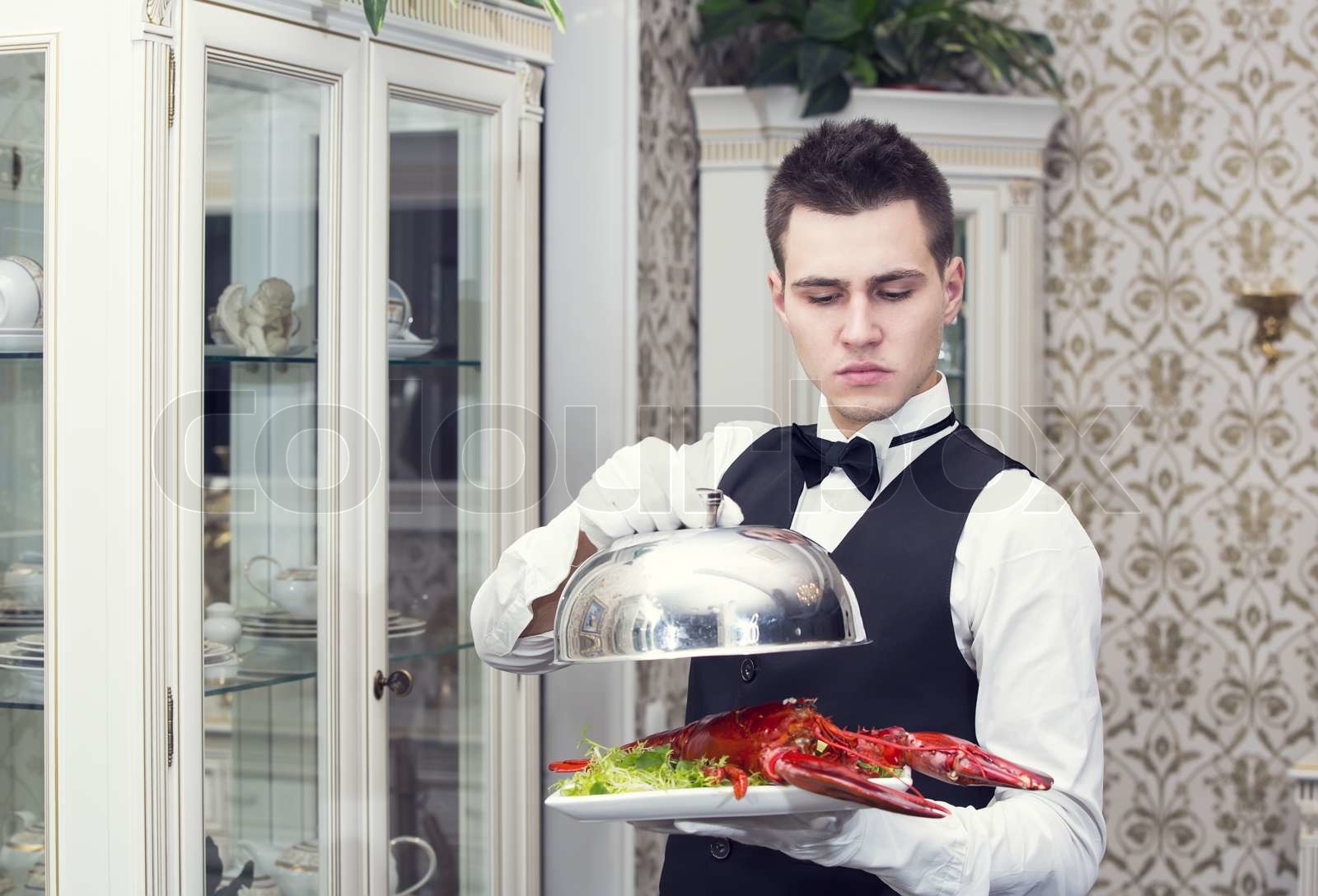 waiter with a tray of food in the restaurant hall | Stock image | Colourbox