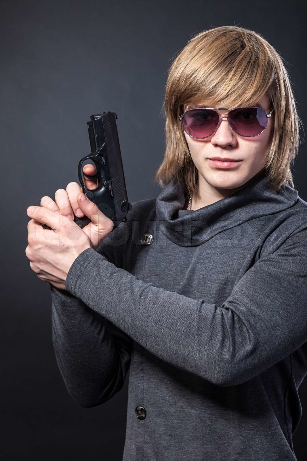 Aiming. Serious man with a gun | Stock image | Colourbox