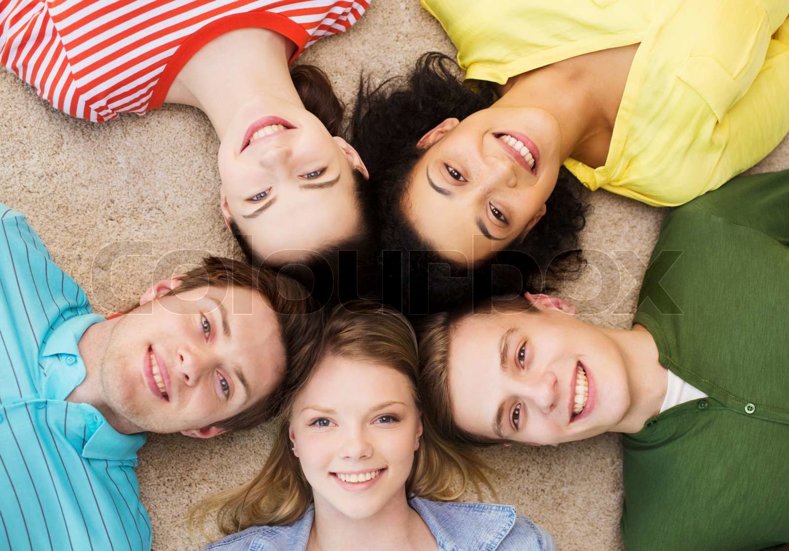group of smiling people lying down on floor | Stock image | Colourbox
