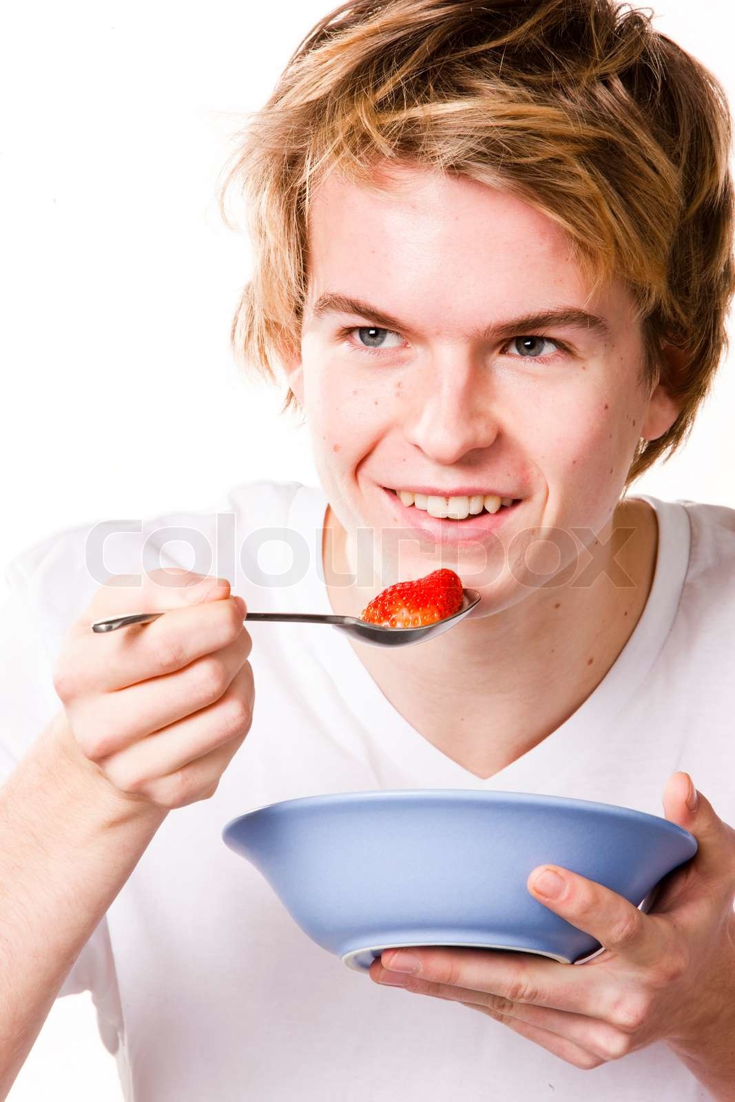 Sund dreng der spiser jordbær | Stock foto | Colourbox