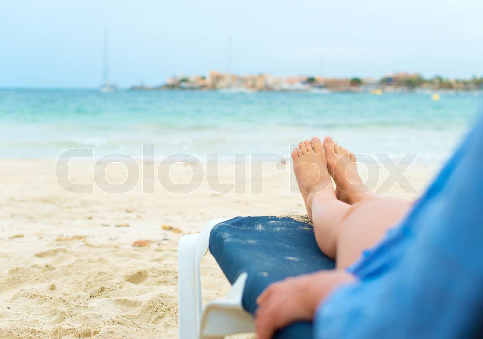 Young woman sunbathing on lounger. Legs. | Stock image | Colourbox