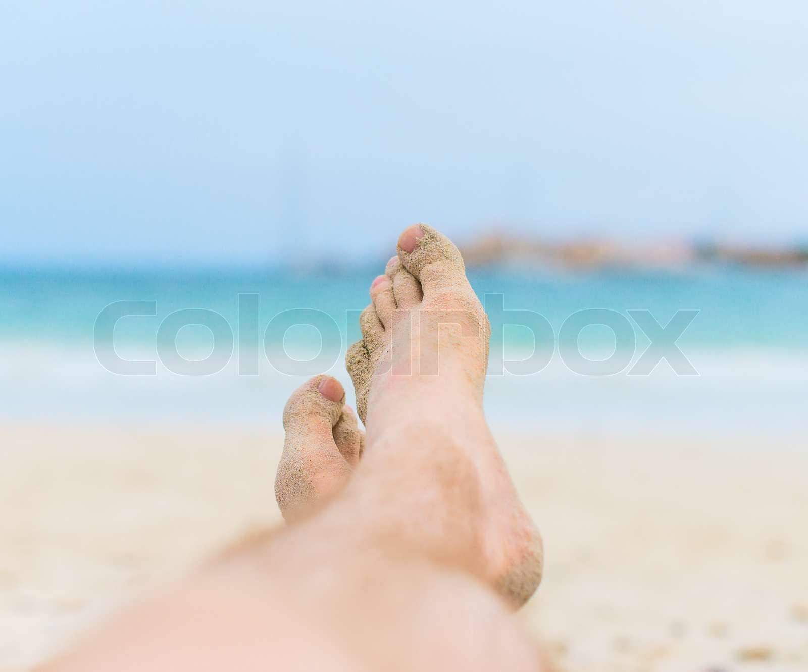 Man sunbathing on the beach. Legs. | Stock image | Colourbox
