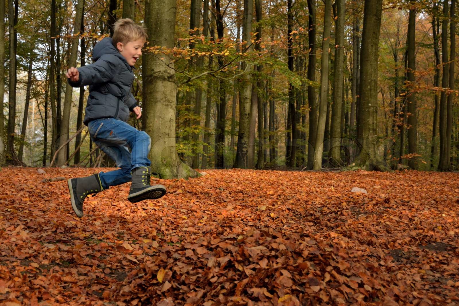 Om efteråret elsker børn at lege i skoven og springe rundt i de visne ...