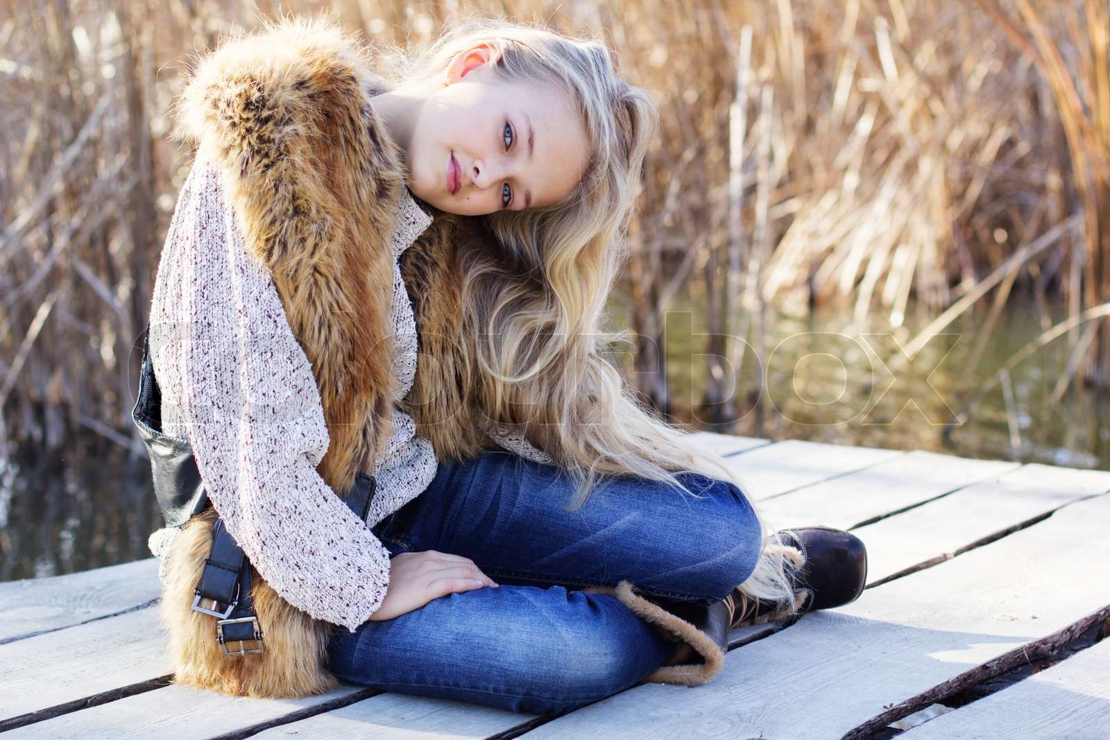 Cute little girl is resting near lake | Stock image | Colourbox