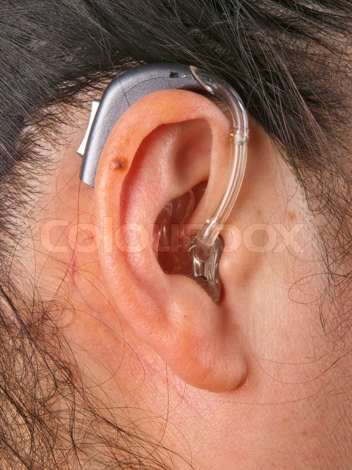 Woman wearing hearing aid | Stock image | Colourbox