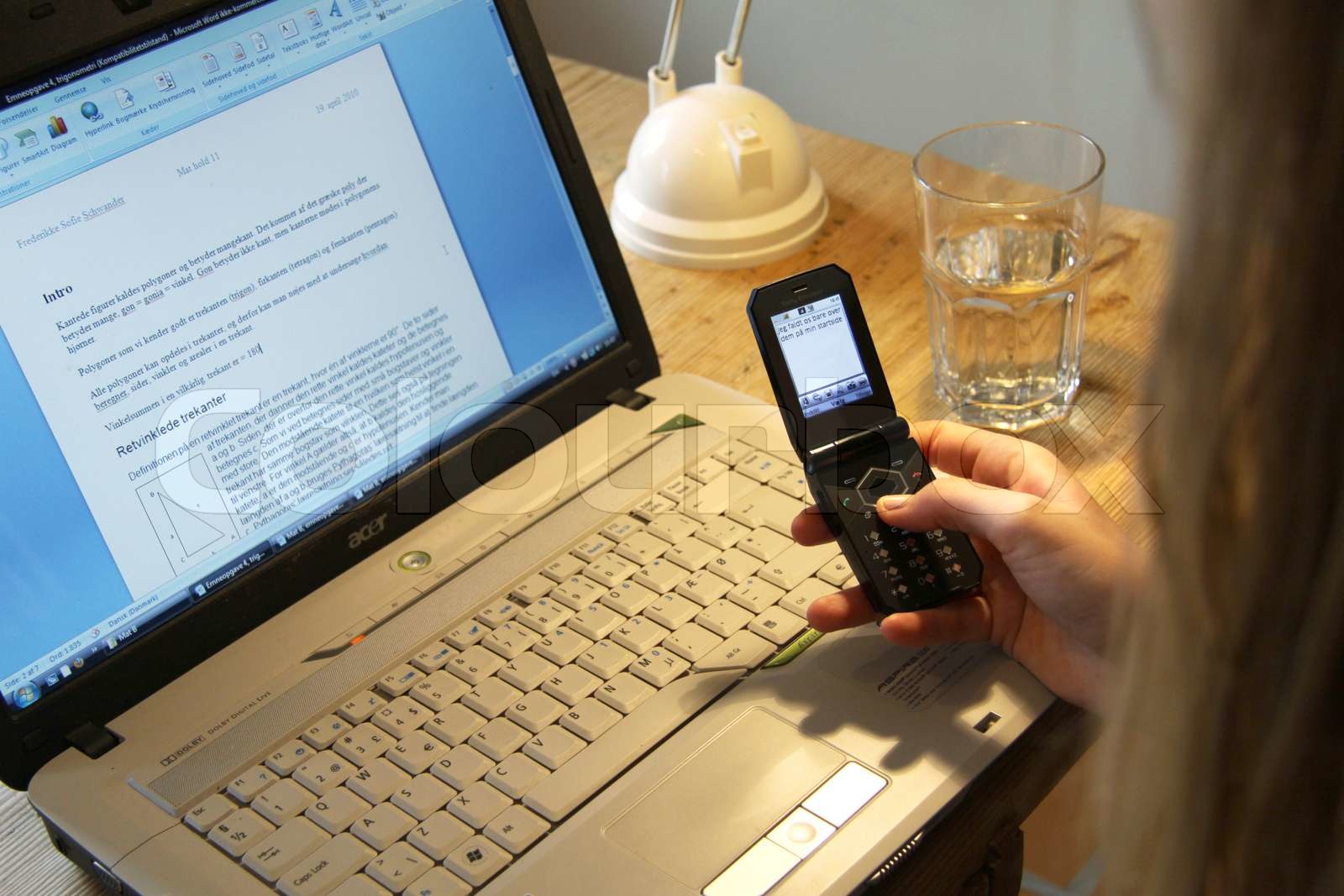 Young girl student with mobile phone making homework | Stock image ...