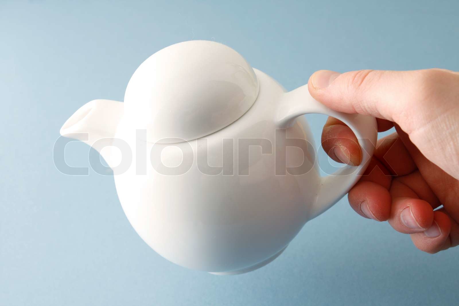 A hand holding a tea pot | Stock image | Colourbox