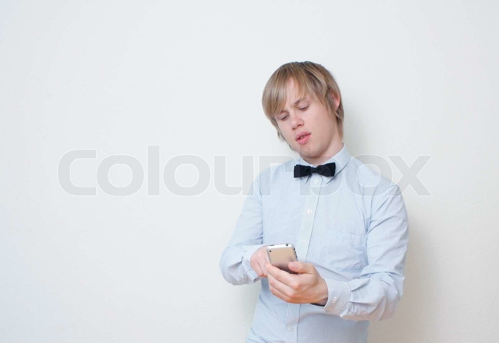 A teenage boy sending a text message on his phone | Stock image | Colourbox