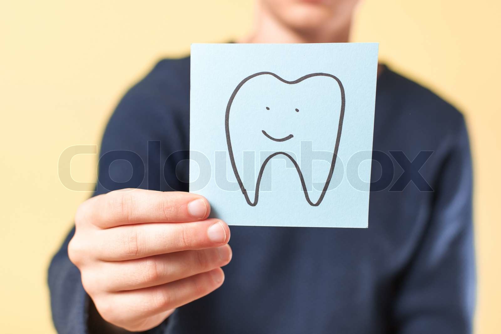 drawing a picture in his hand tooth | Stock image | Colourbox