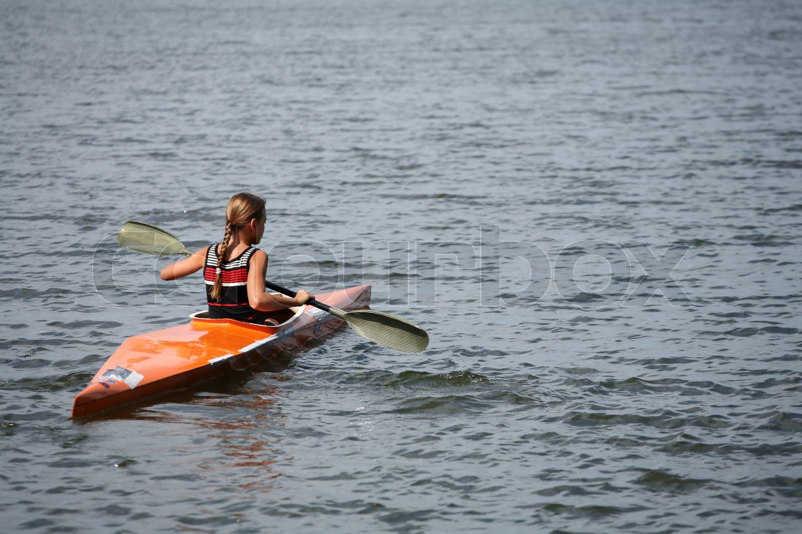 a lake in denmark with a blond girl on a kayak | Stock image | Colourbox