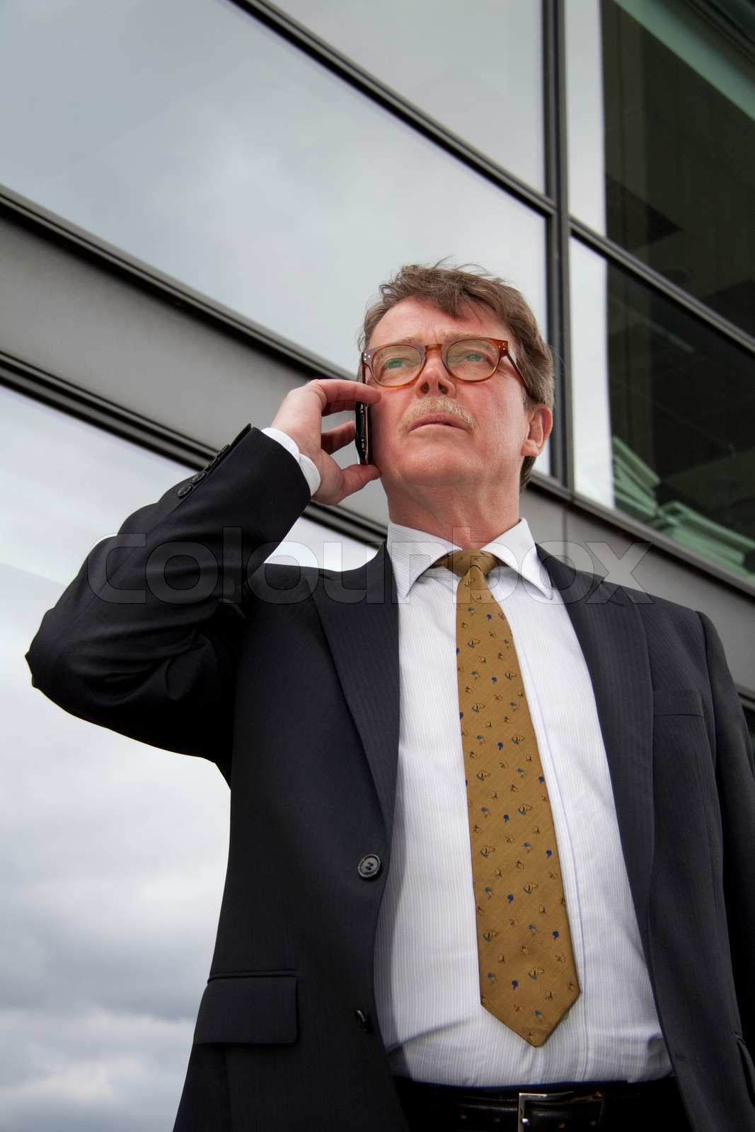 Business man in front of modern office building | Stock image | Colourbox