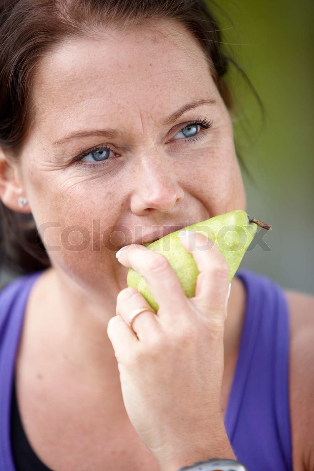 Aktiv kvinde der spiser en frisk pære | Stock foto | Colourbox