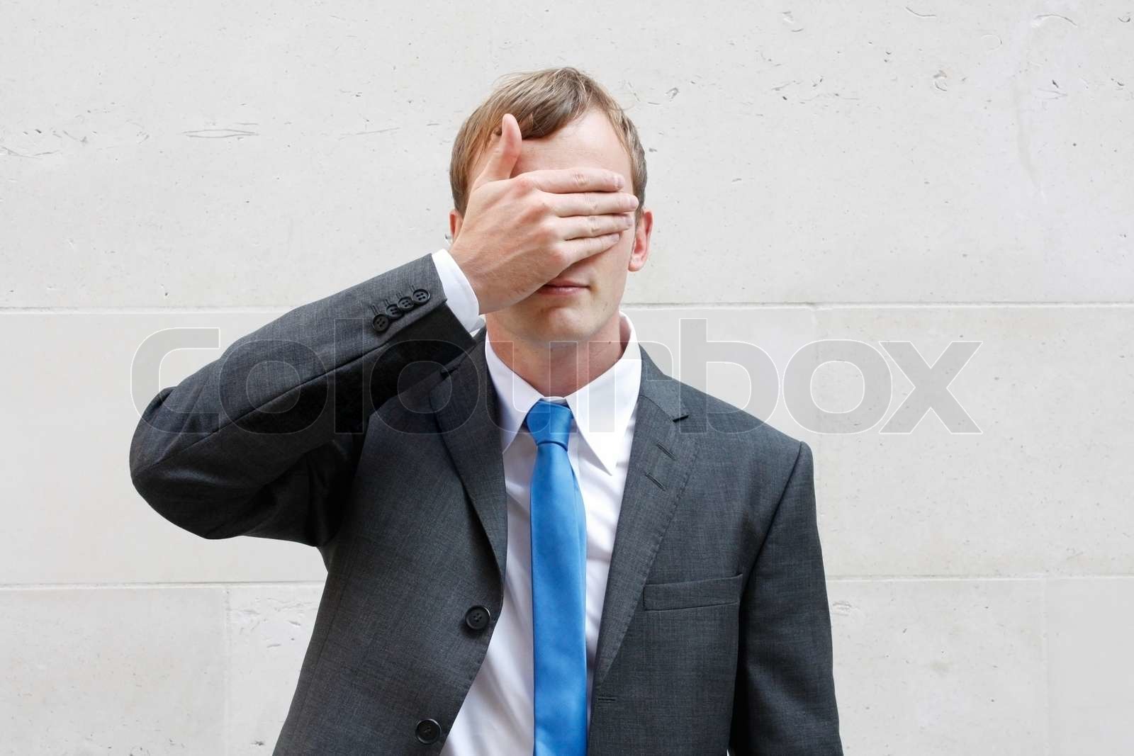 A business man holding hand on his face | Stock image | Colourbox