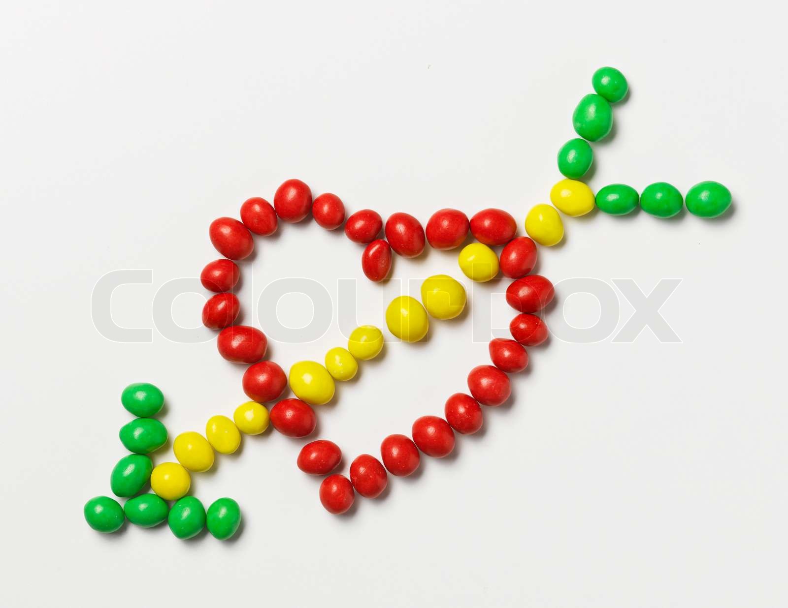 Et hjerte med en pil igennem formet af farverigt slik | Stock foto ...