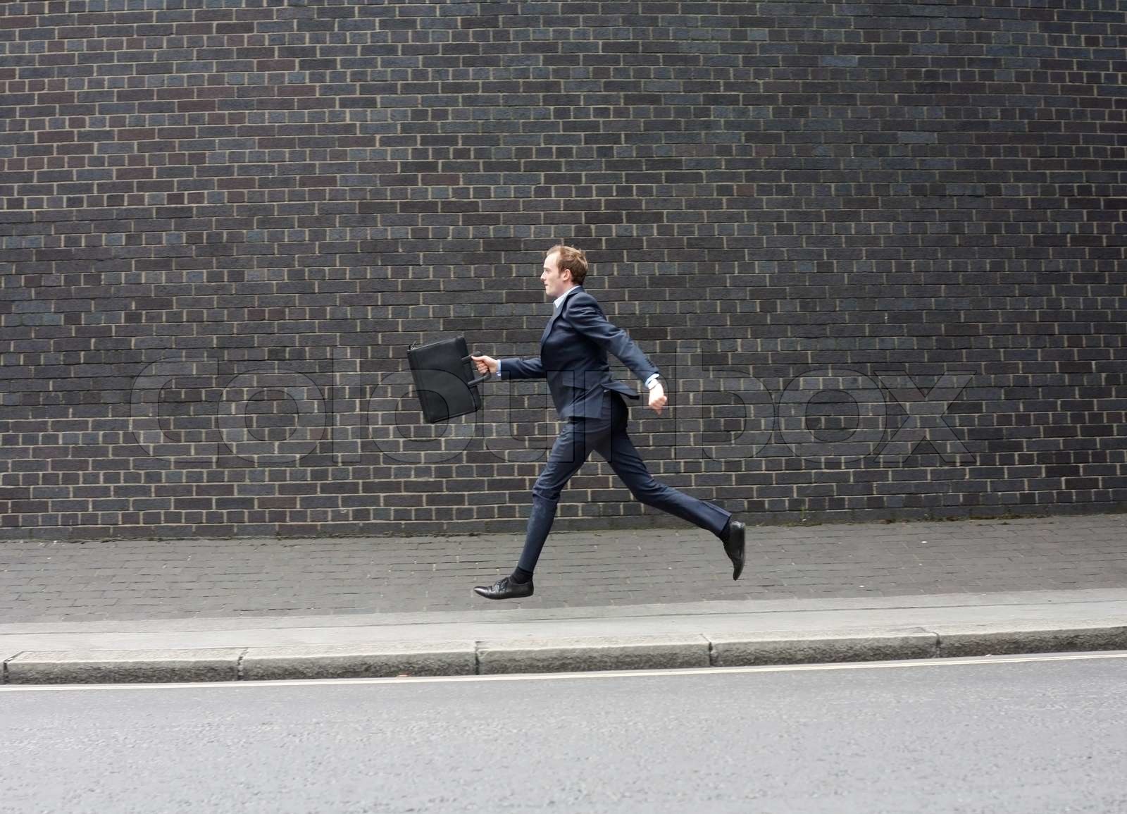 Businessman running on pavement | Stock image | Colourbox