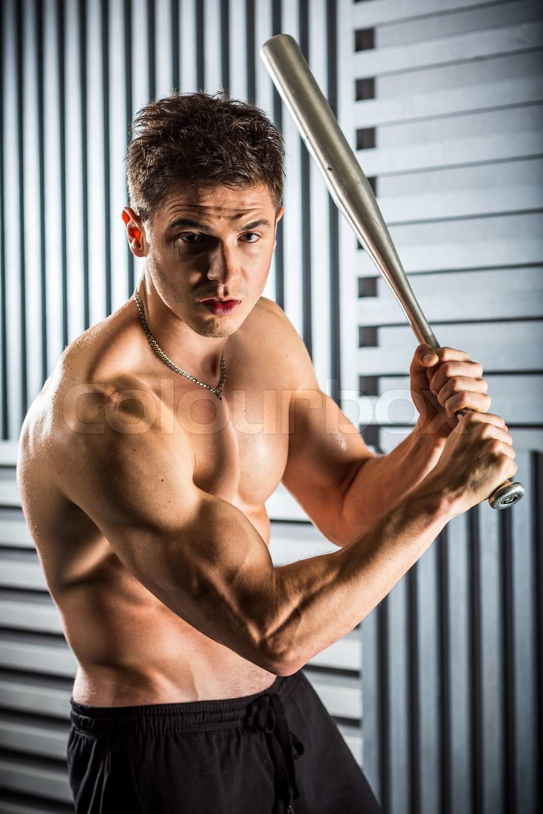 muscular man posing with a bat | Stock image | Colourbox