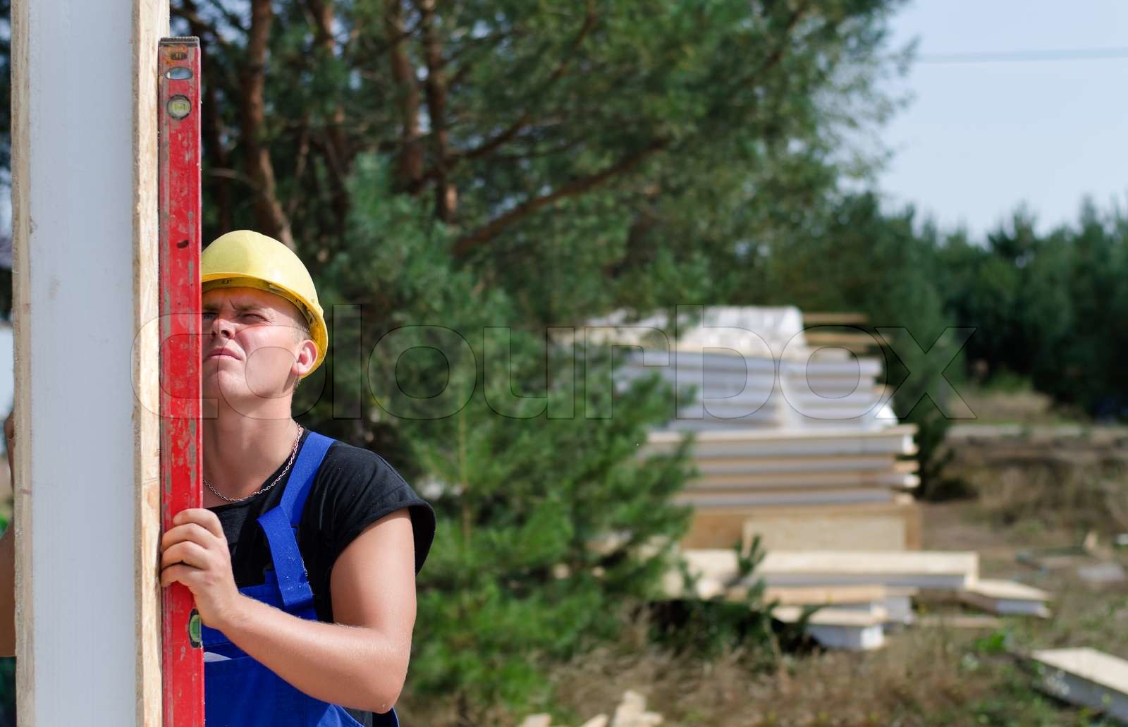 Builder using a builders level | Stock image | Colourbox