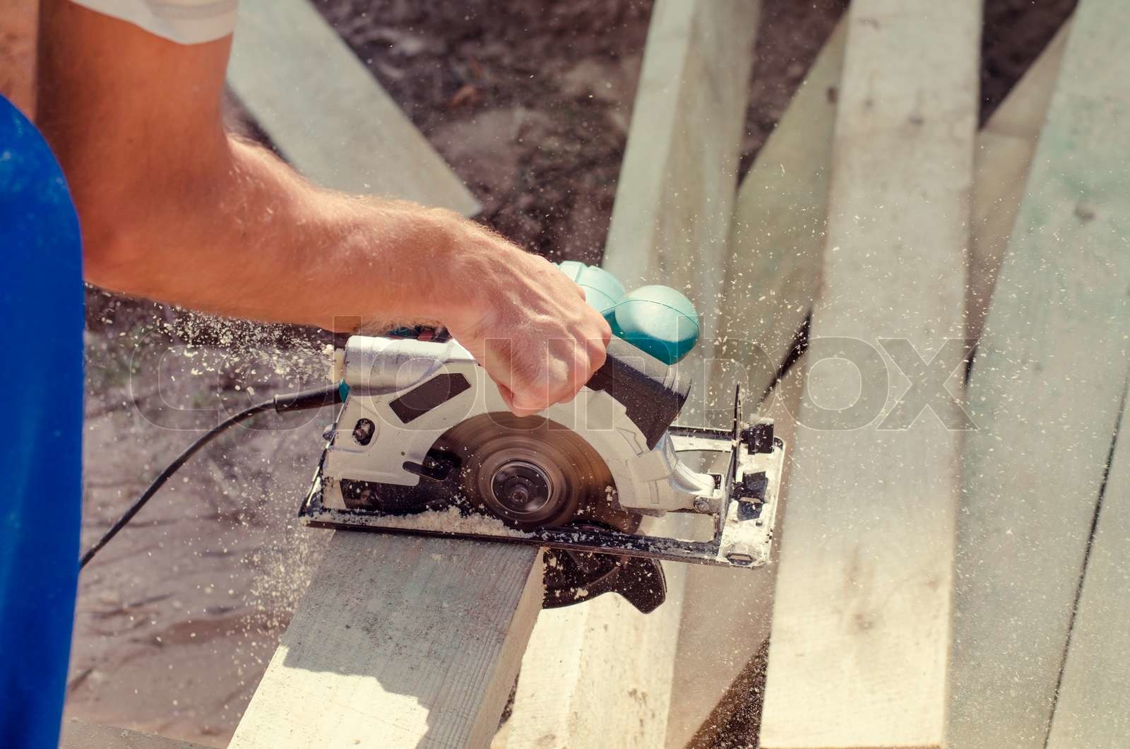 Workman cutting a wooden beam | Stock image | Colourbox