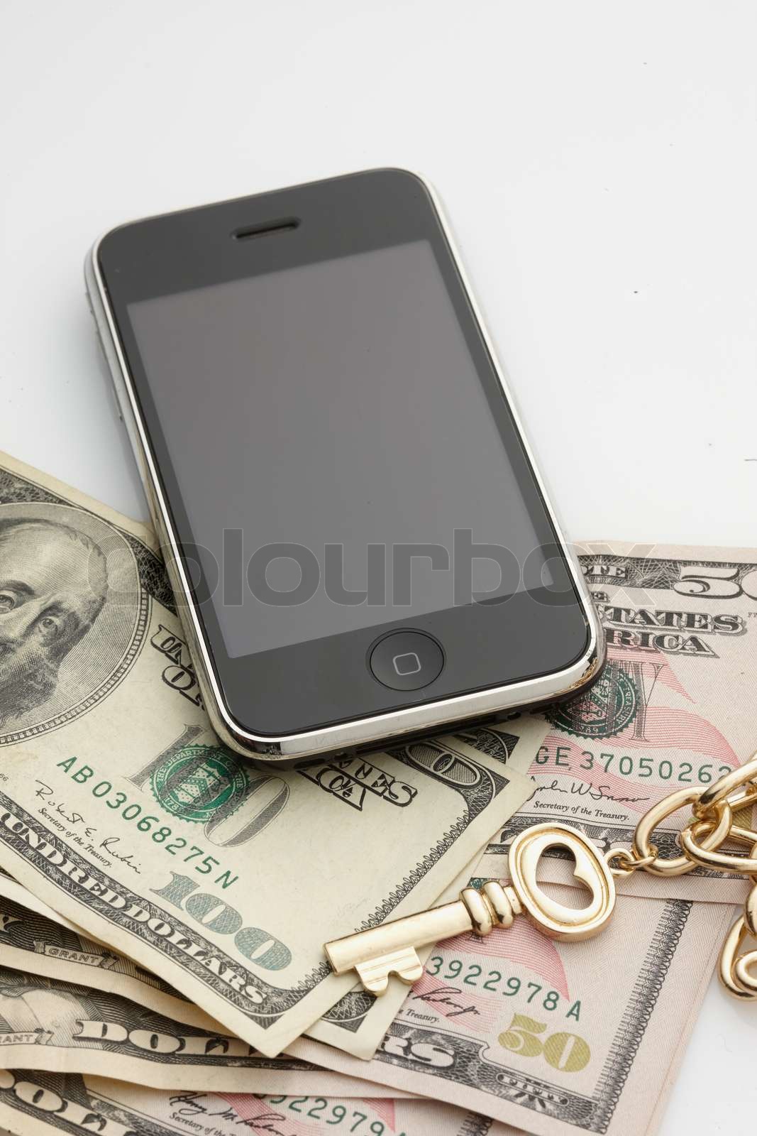 An expensive smartphone with stack of money and coins | Stock image ...