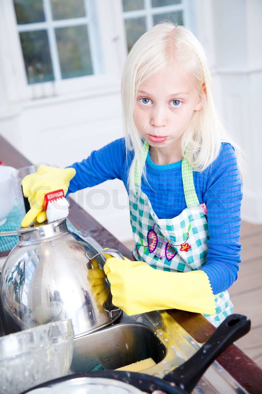 A young girl busy cleaning the kitchen | Stock image | Colourbox