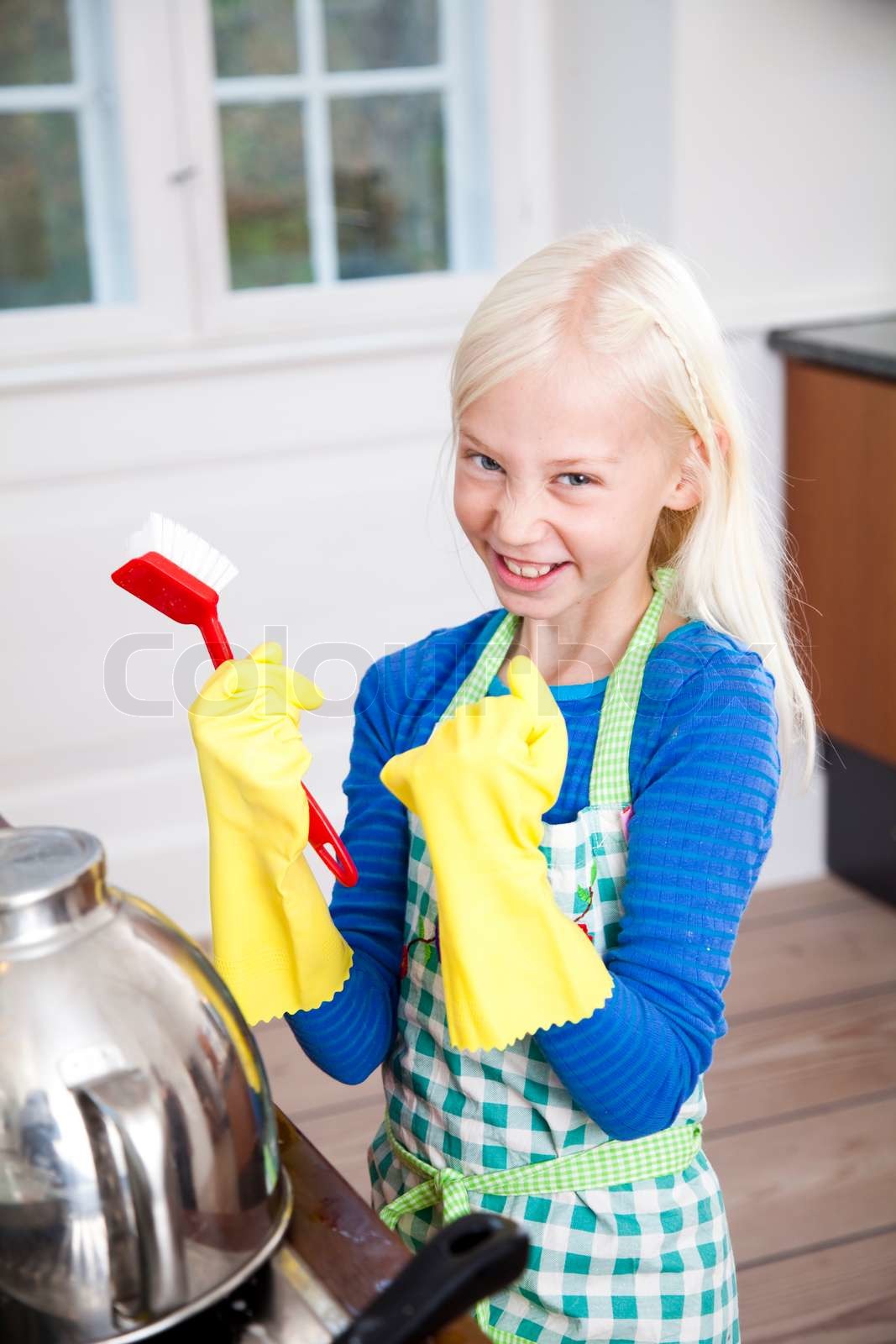 A young girl busy cleaning the kitchen | Stock image | Colourbox