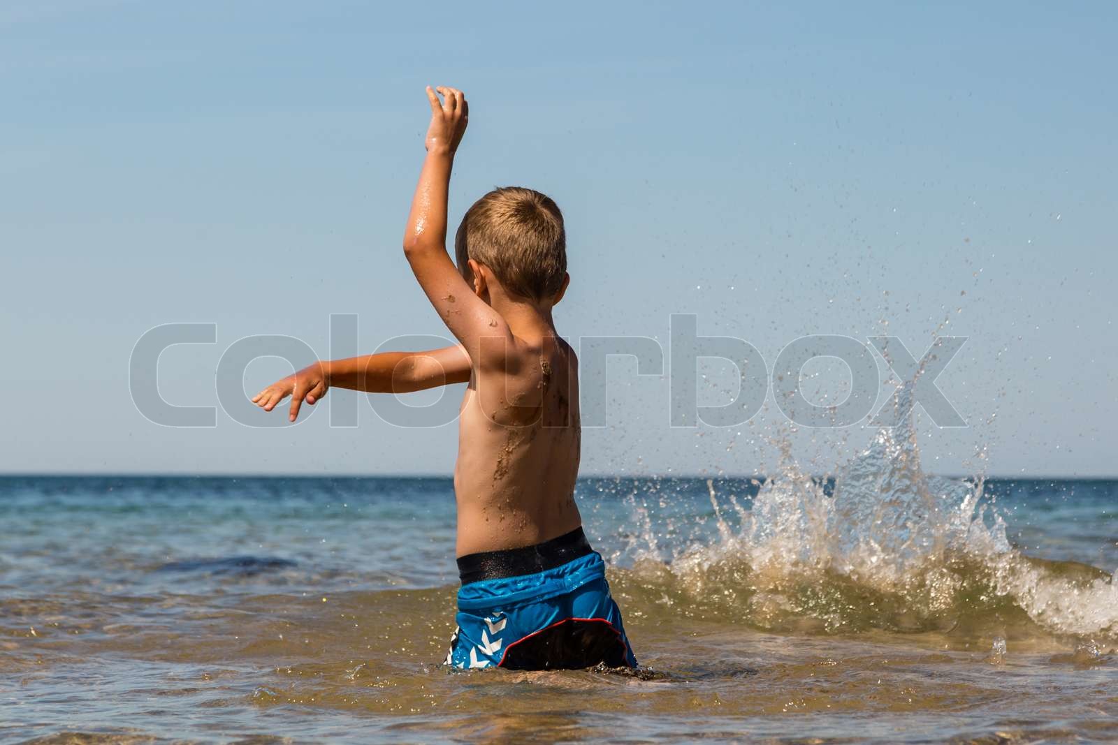 Boy playing in the ocean | Stock image | Colourbox