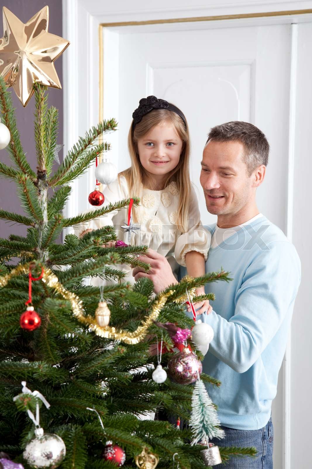 A father and his daughter decorating the Christmas tree | Stock image ...