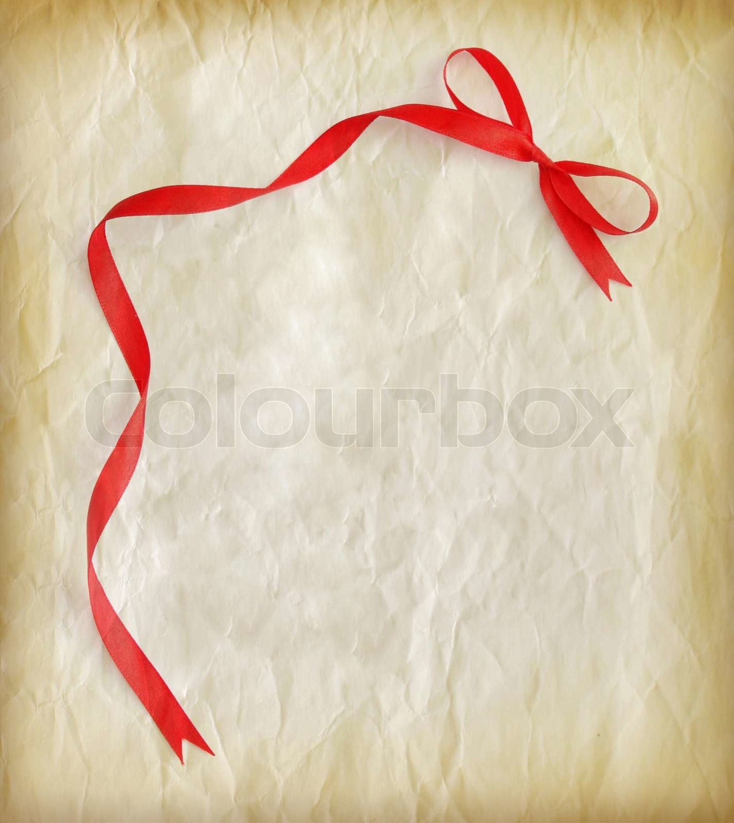 Red ribbon on old paper | Stock image | Colourbox
