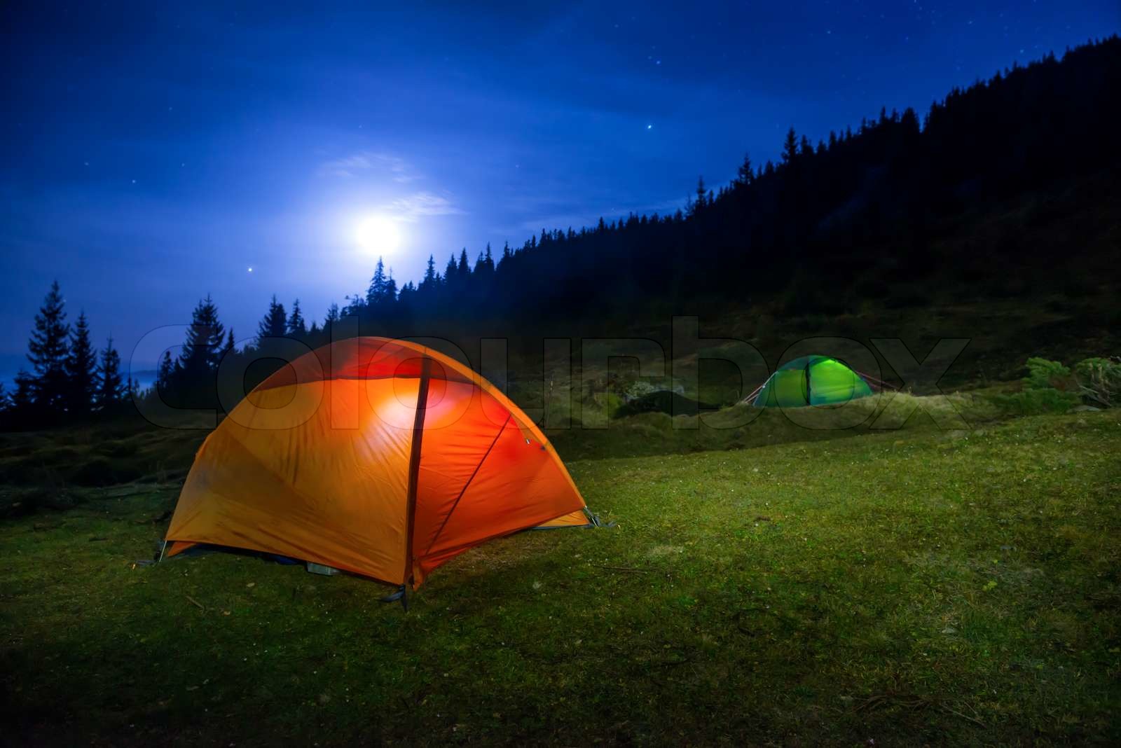 Two Illuminated orange and green camping tents | Stock image | Colourbox