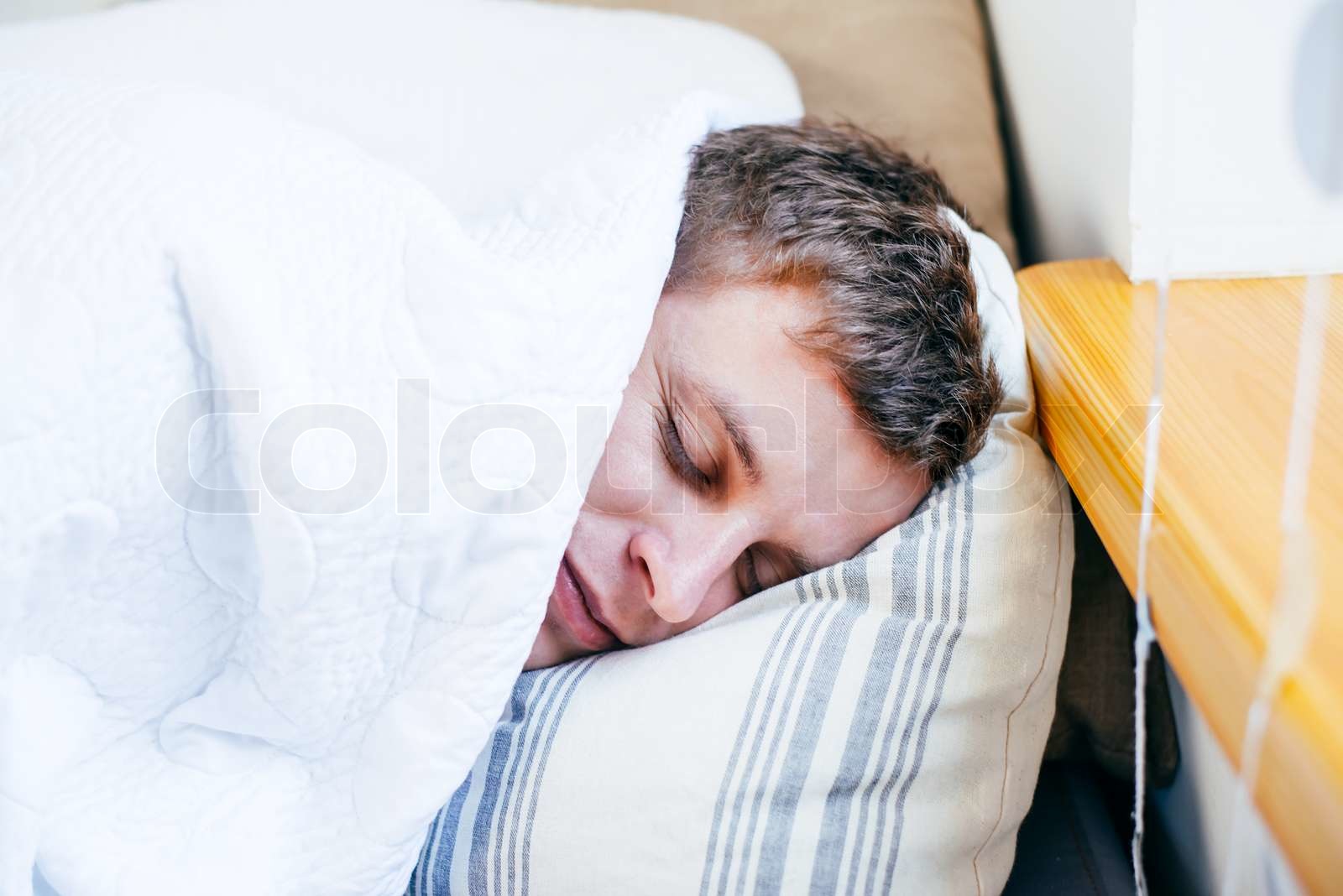 Handsome man sleeping in his bedroom | Stock image | Colourbox
