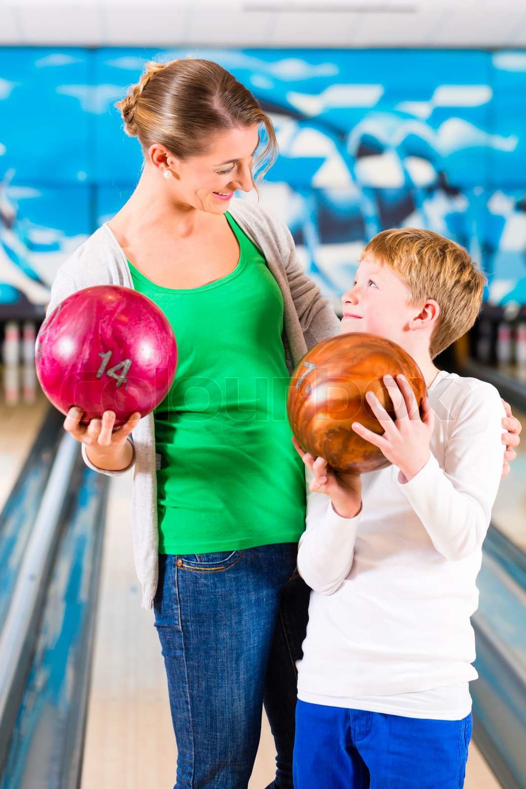 Mother and son playing together at bowling center | Stock image | Colourbox