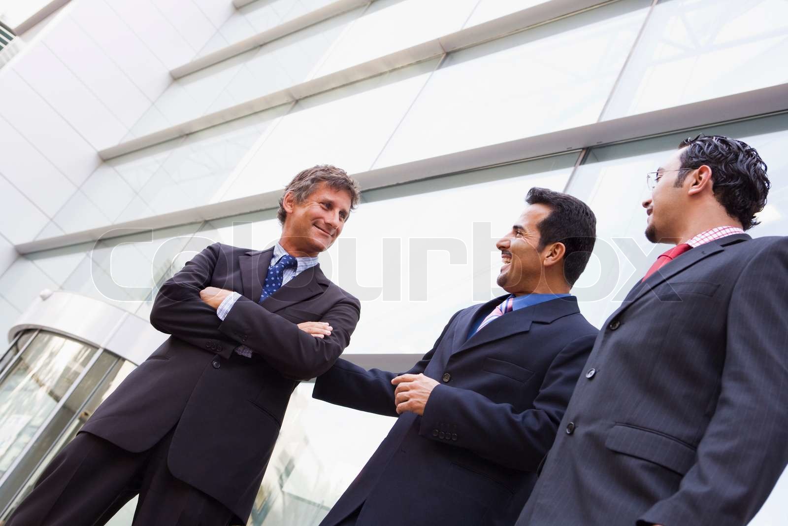Group of businessmen outside modern office building | Stock image ...
