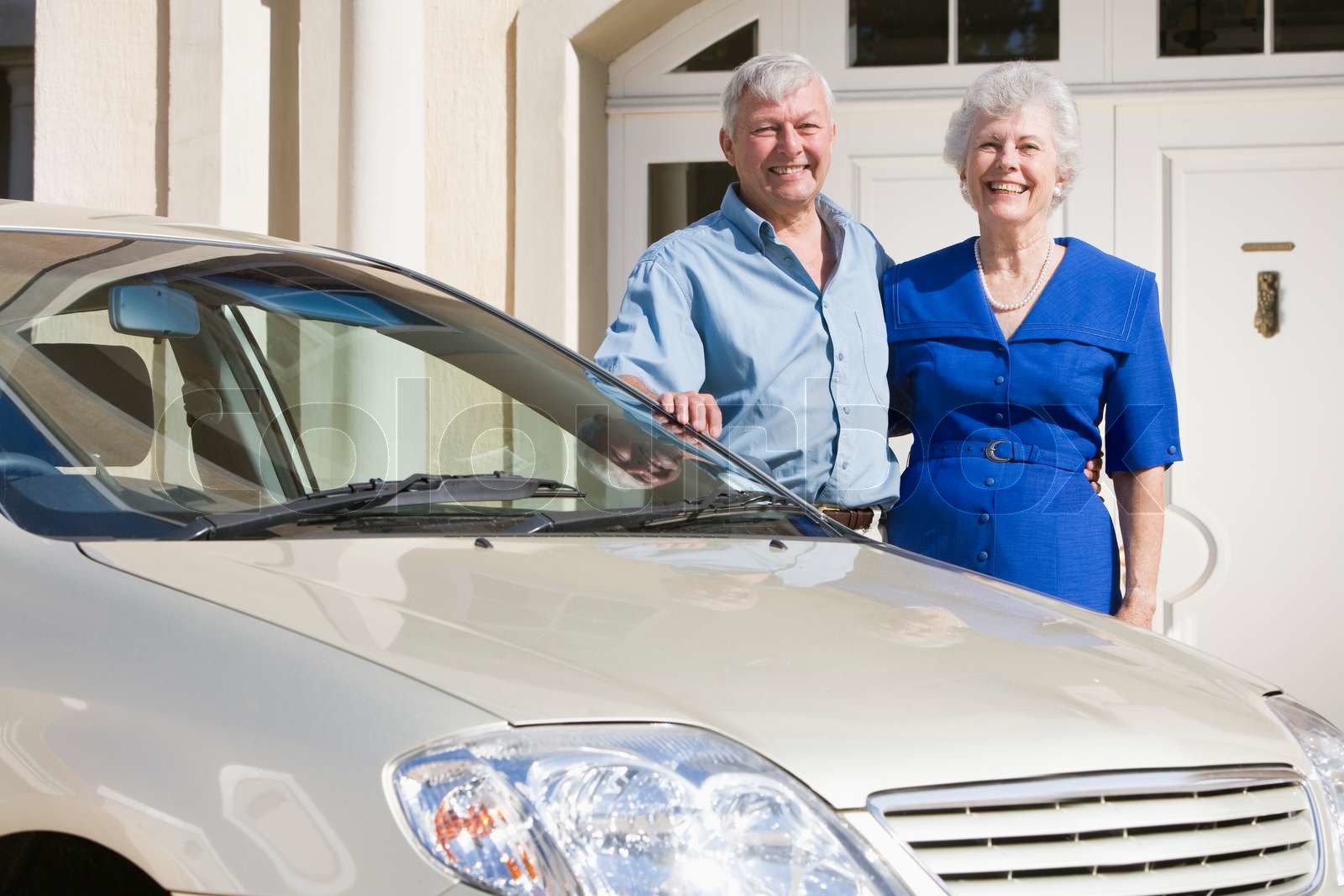 Senior couple standing next to new car outside house | Stock image ...