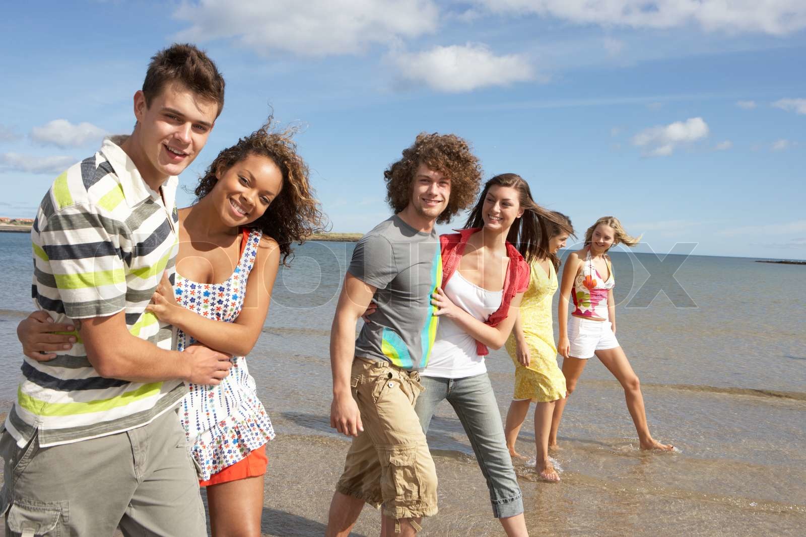 Gruppe unge venner gåture langs Sommer Shoreline | Stock foto | Colourbox