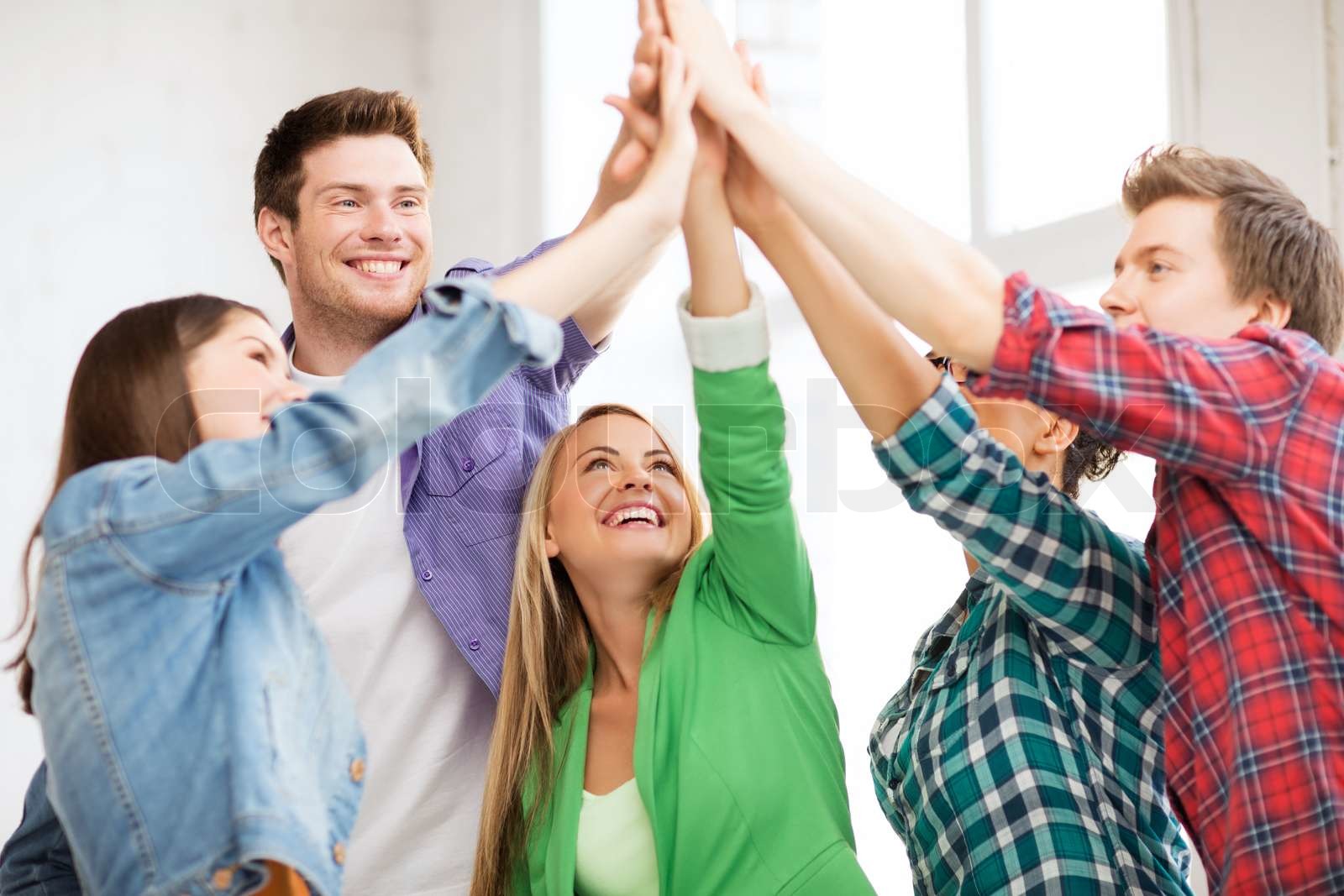 happy students giving high five at school | Stock image | Colourbox