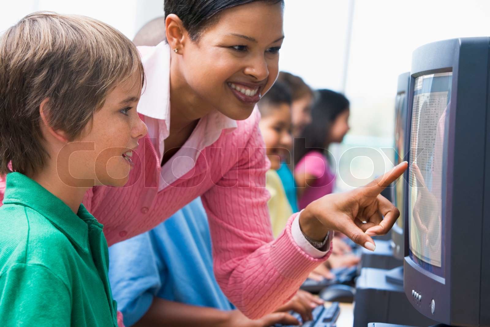 Elementary school computer class with teacher | Stock image | Colourbox