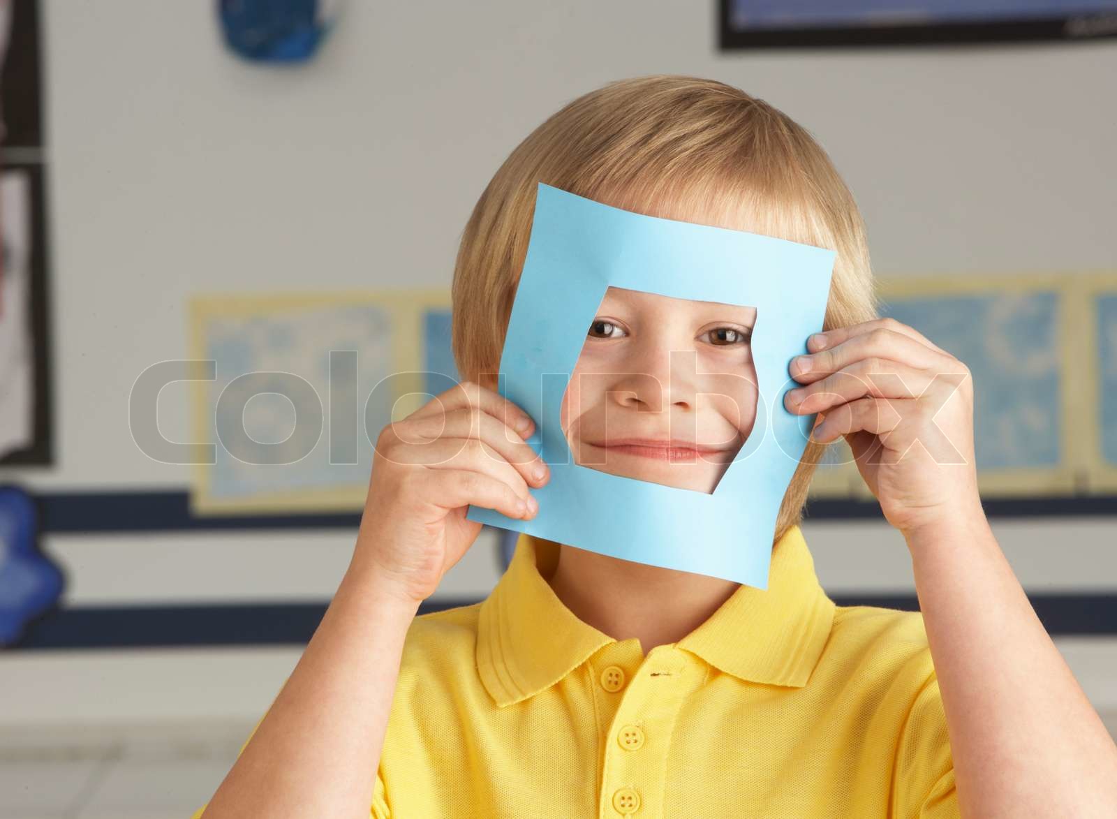 Male Primary School Cutting Out Paper Shapes In Craft Lesson | Stock ...