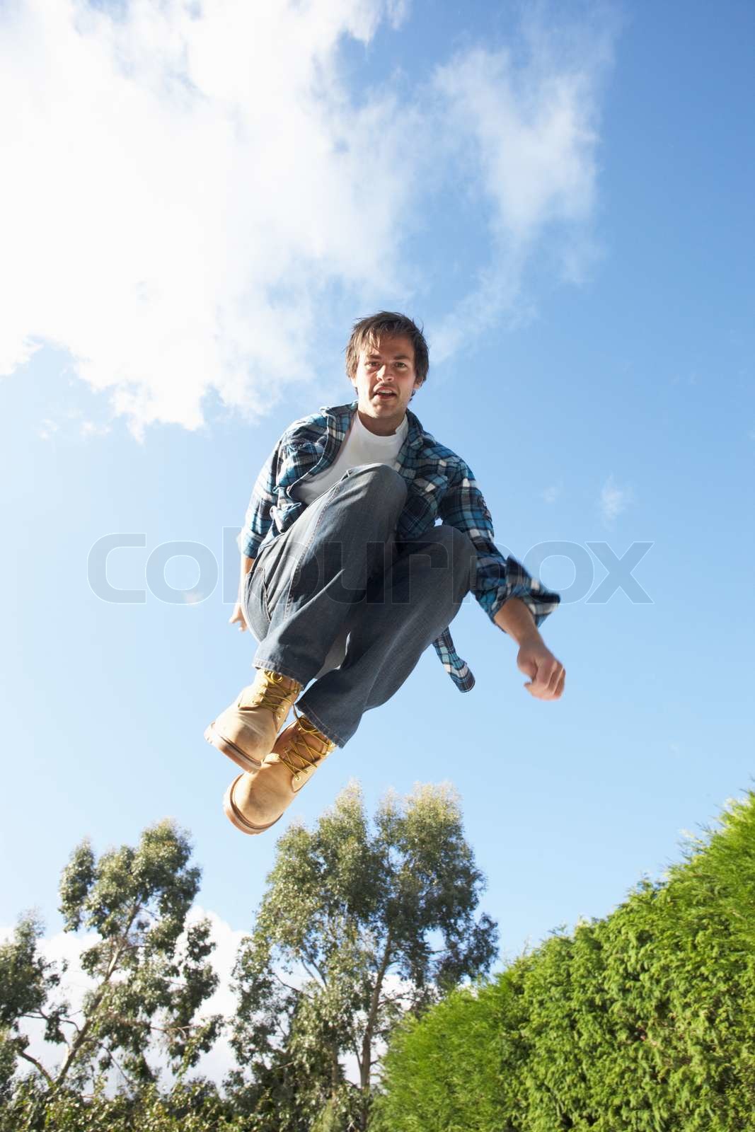 Young Man Jumping On Trampoline Caught In Mid Air | Stock image | Colourbox