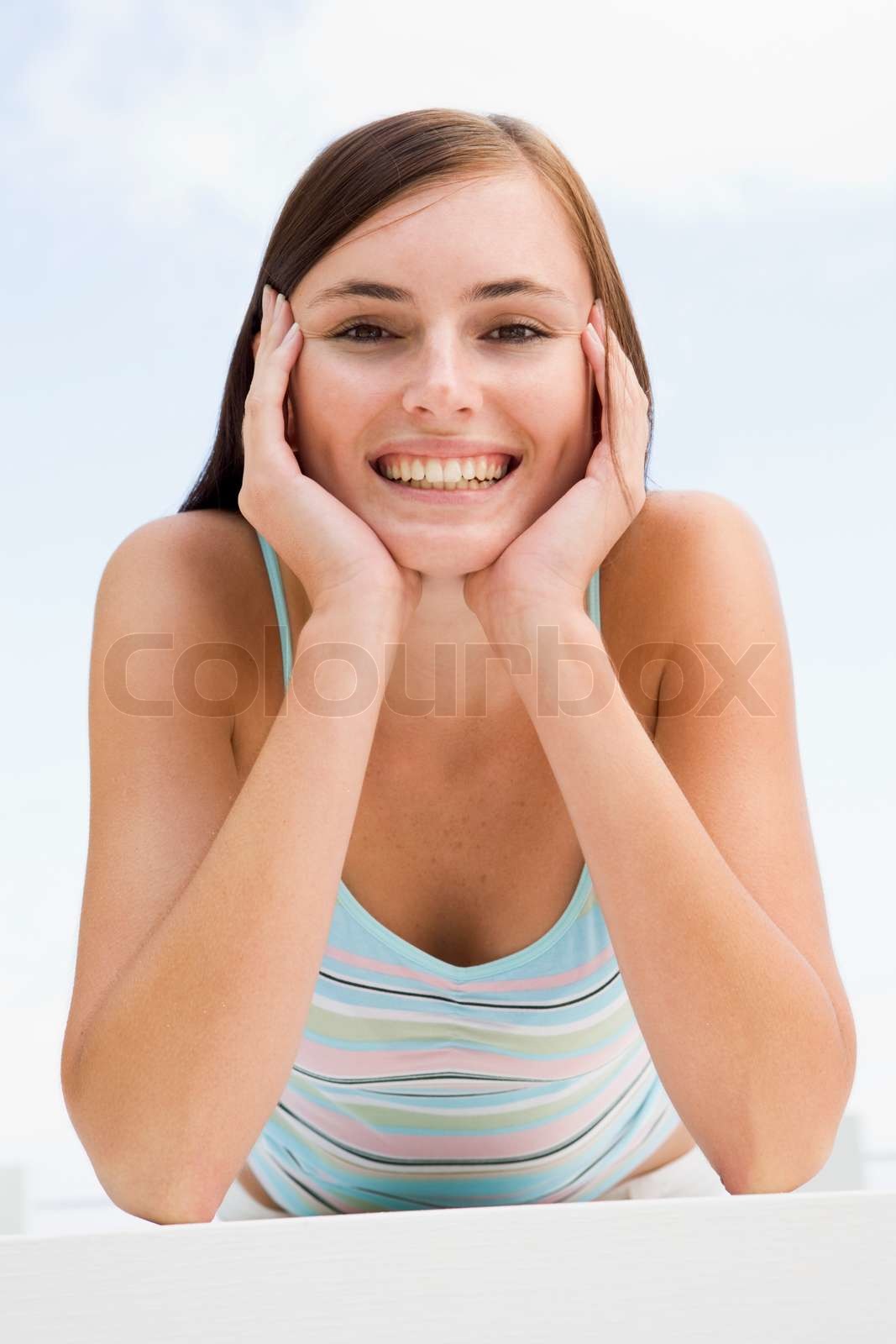 Young woman relaxing outside resting head on hands | Stock image ...