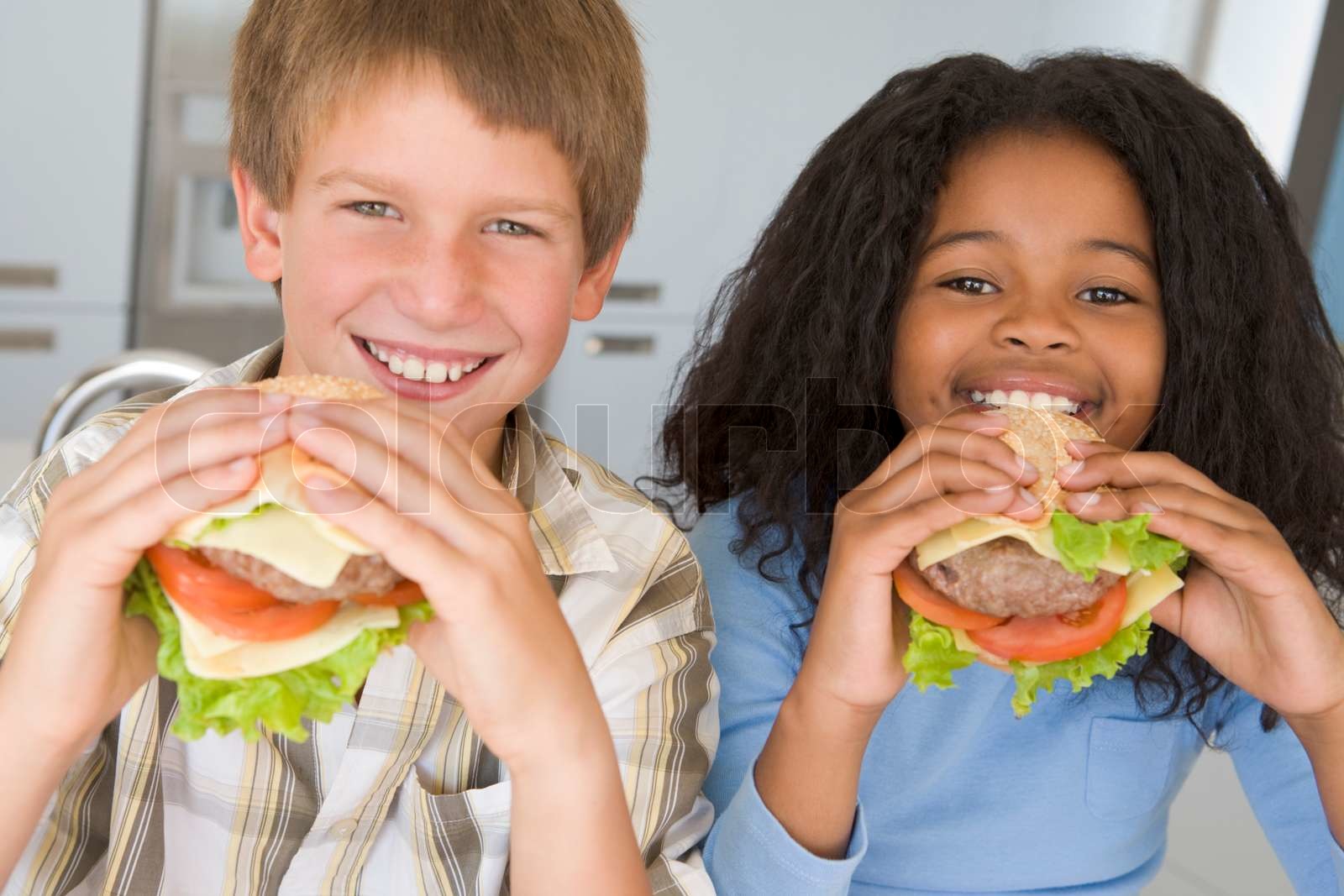 Dreng og pige spiser sundt burgere | Stock foto | Colourbox