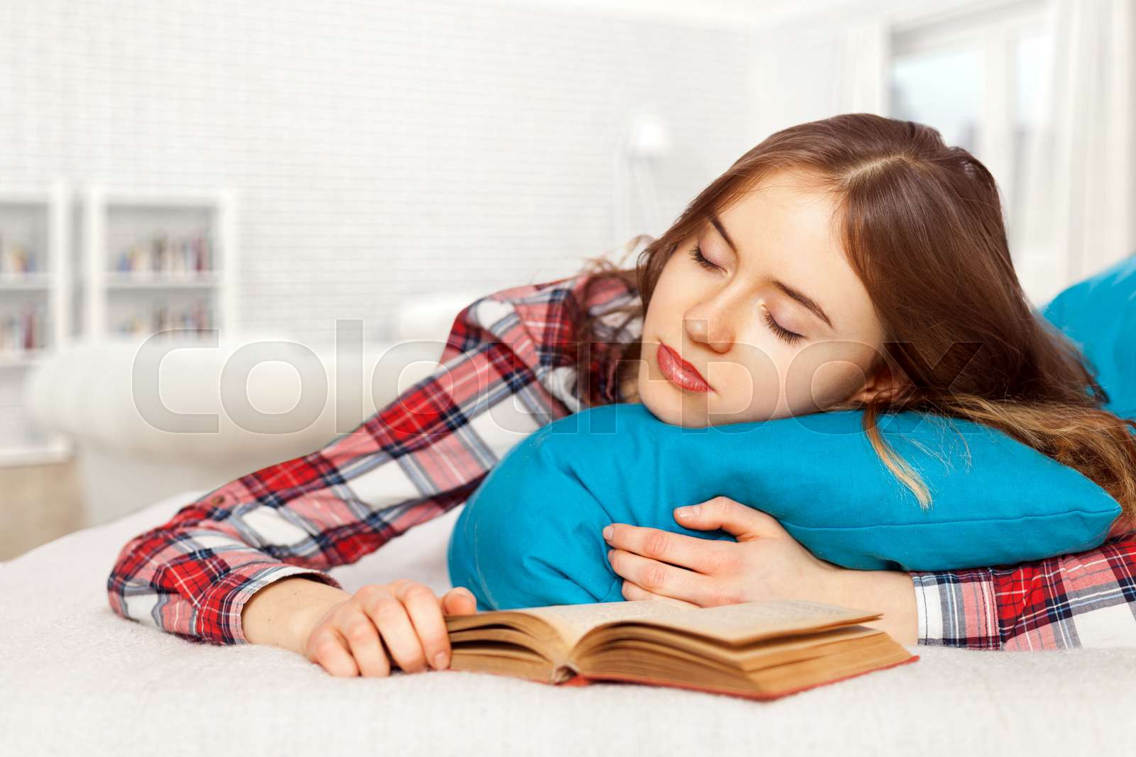 Young girl slepping with a book in bed | Stock image | Colourbox