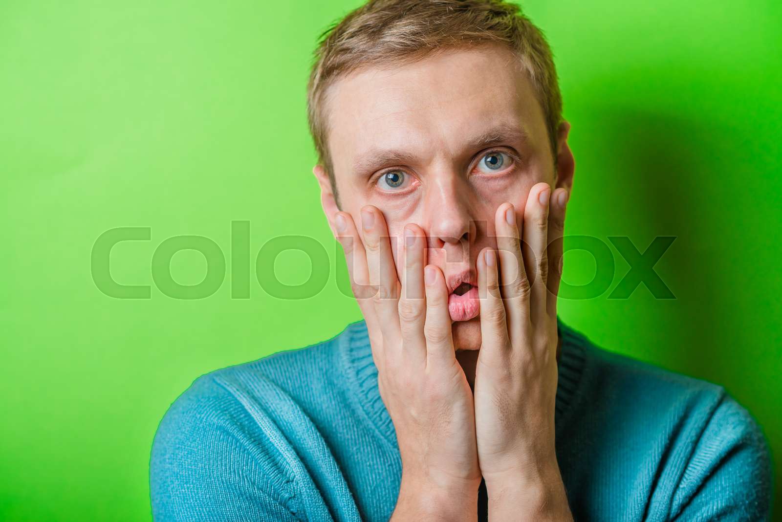 a young man dragging face down with hands | Stock image | Colourbox