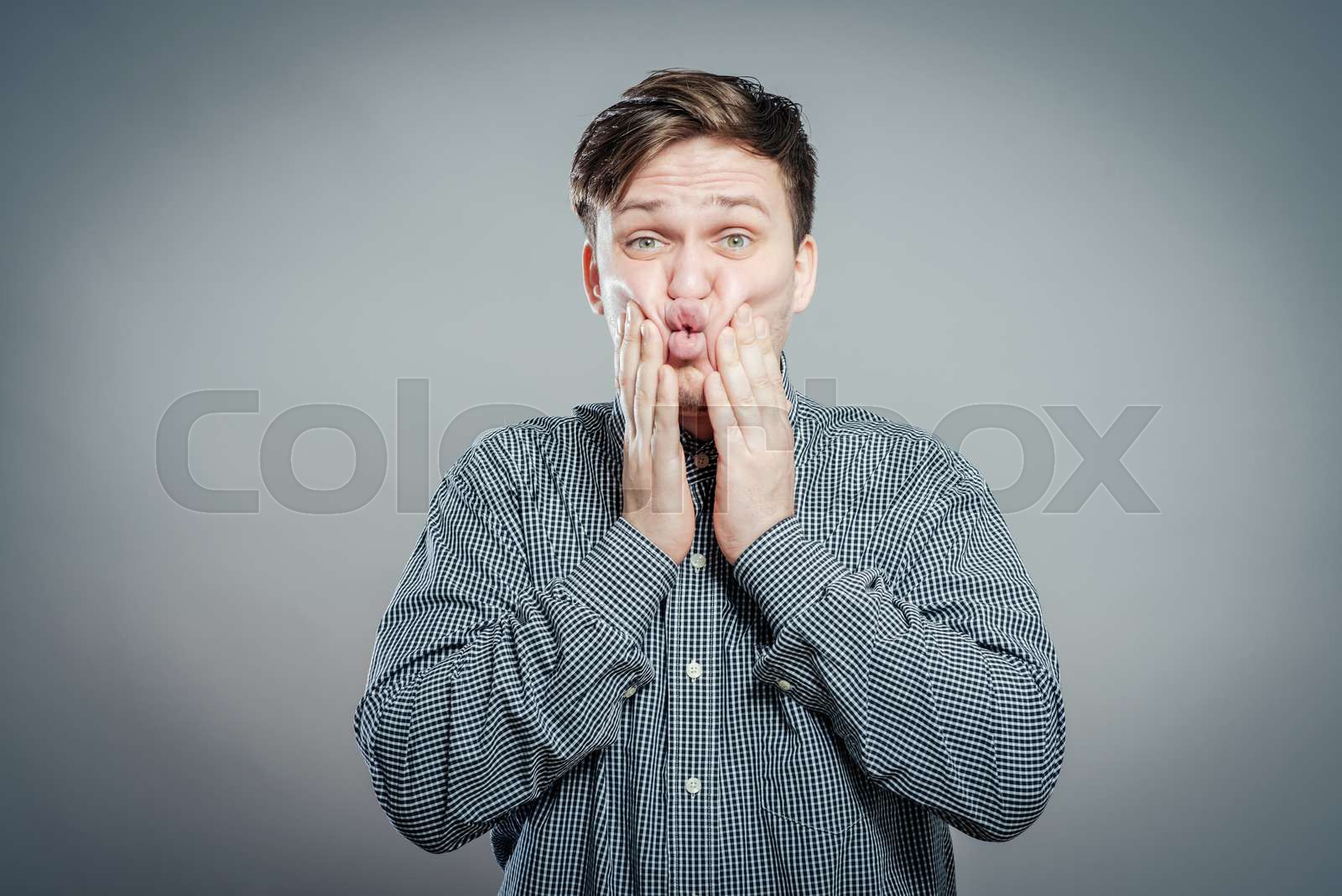 a young man in shock with hands on face | Stock image | Colourbox