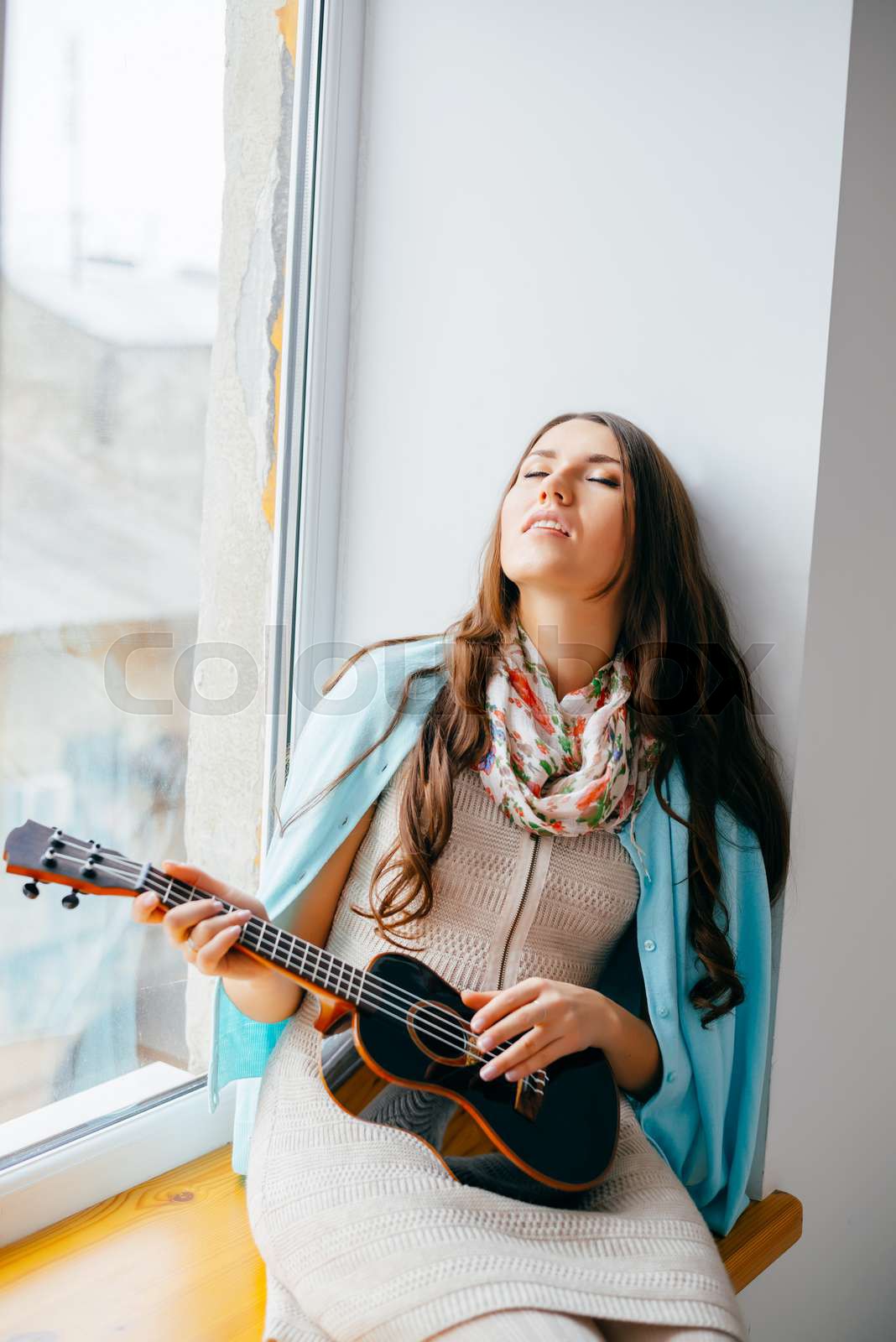 girl sitting on the window. playing guitar | Stock image | Colourbox