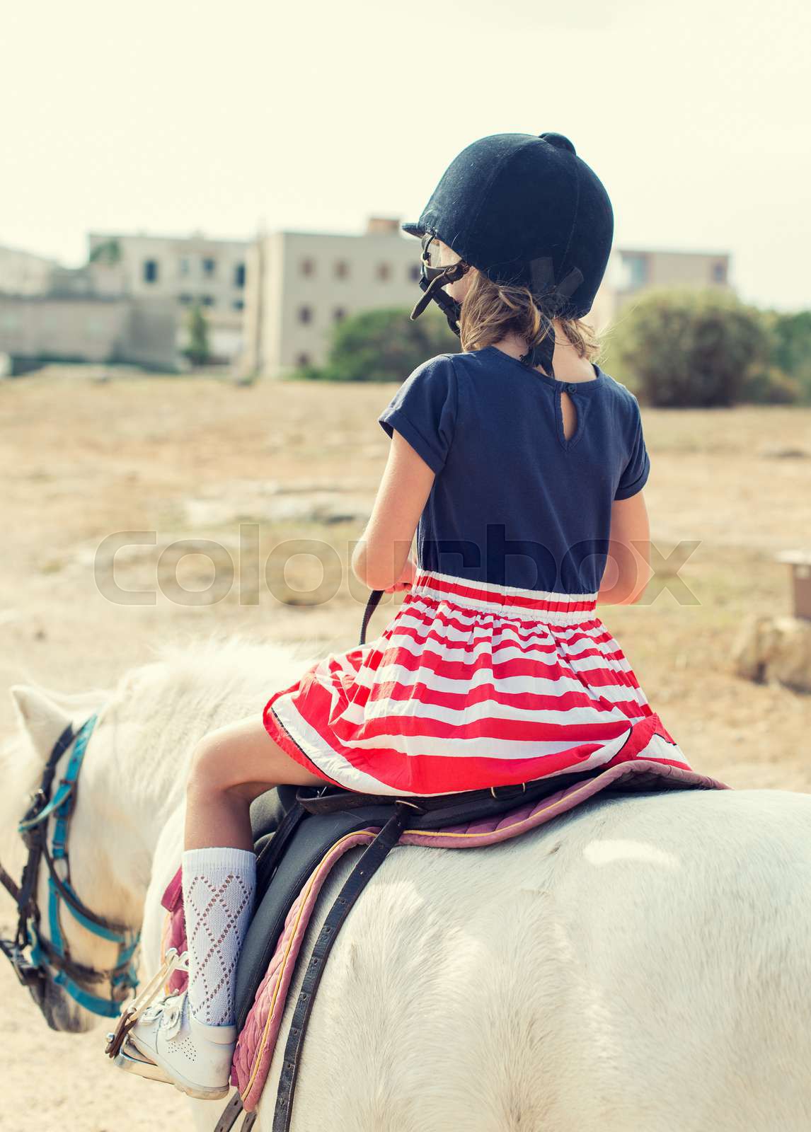 Portrait of little girl riding pony. From the back. | Stock image ...